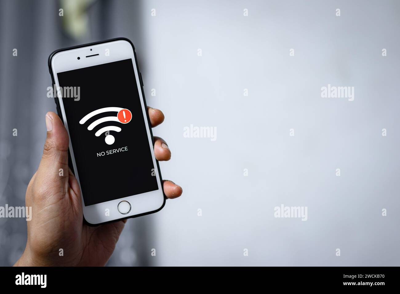 Male hand holding a smart phone with sign no service on screen ...