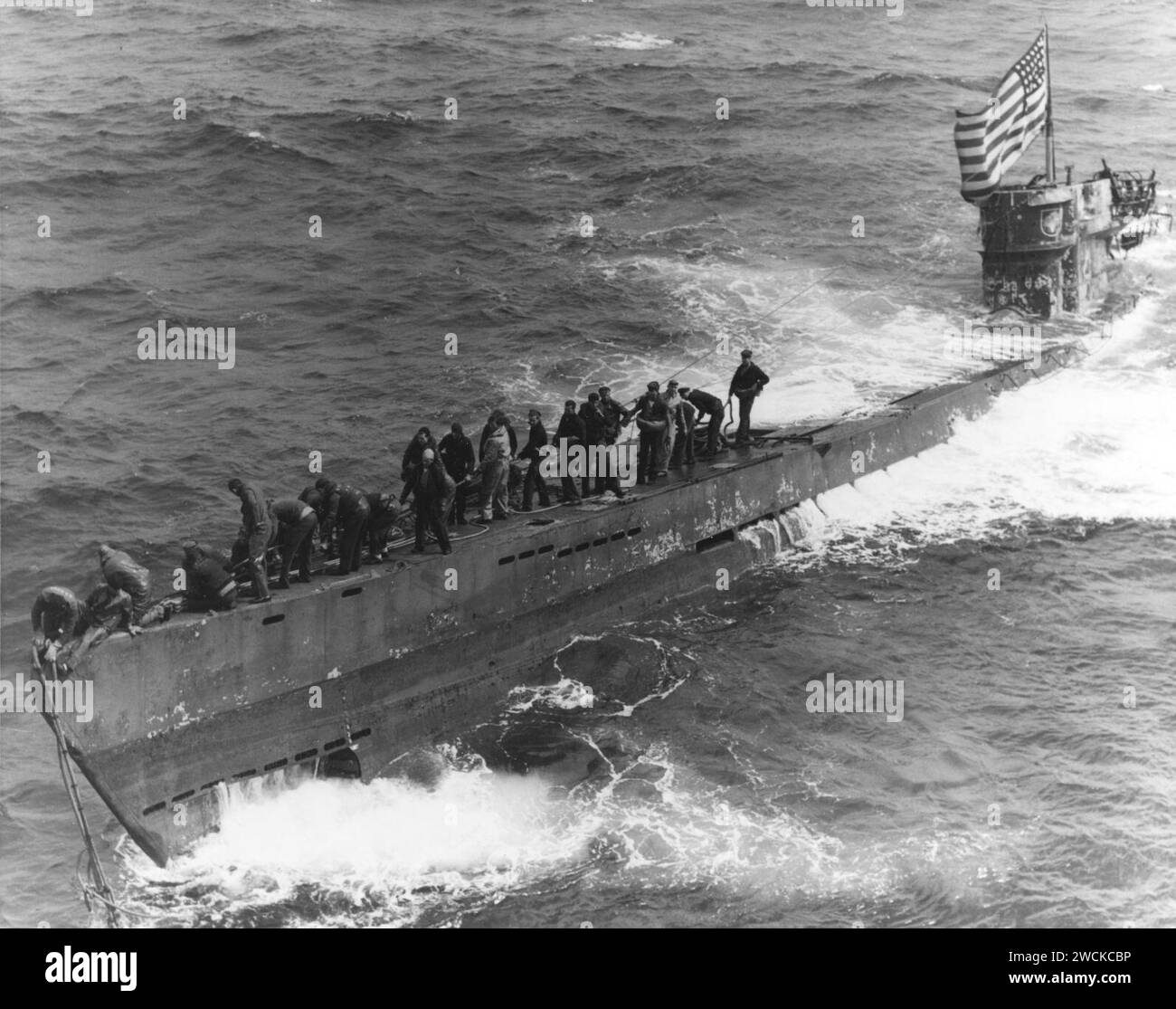 A U.S. Navy boarding party working to secure a tow line to the bow of ...