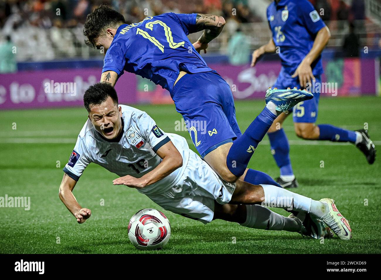 Doha, Qatar. 16th Jan, 2024. Kyrgyzstan's Alykulov Gulzhigit (L) falls ...