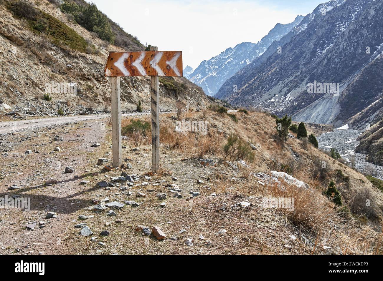 Dangerous driveway next to the cliff. Red road sign with white left ...
