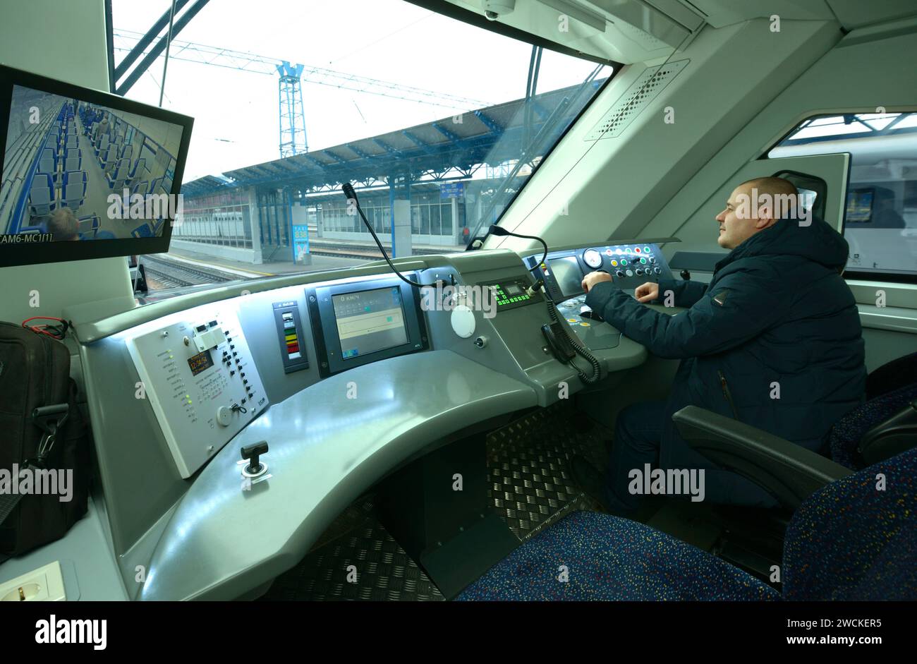 Man train driver sitting in the cabin of locomotive of passenger train ...