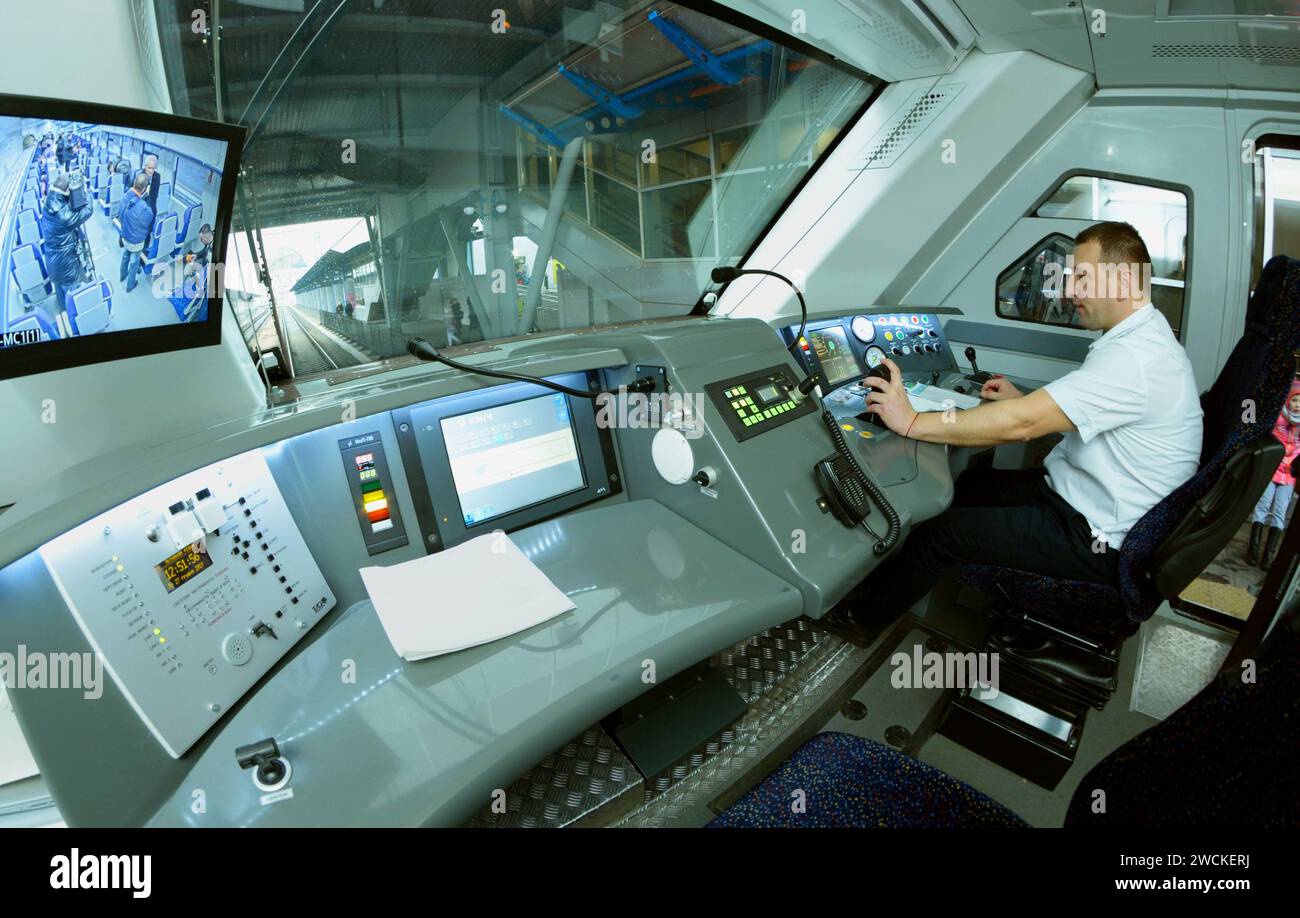 Man train driver sitting in the cabin of locomotive of passenger train ...