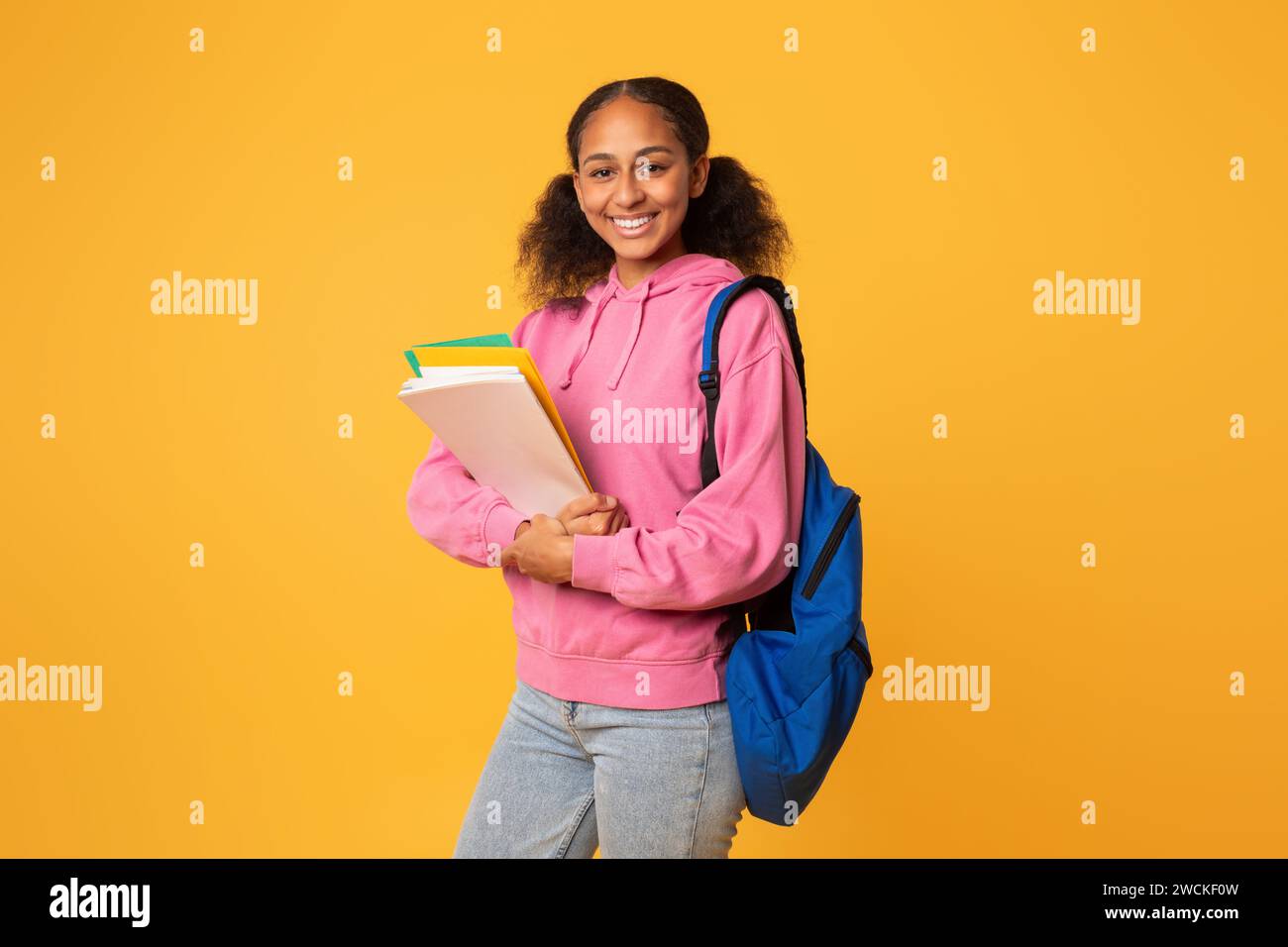 black teen girl student posing with backpack and notebooks, studio ...