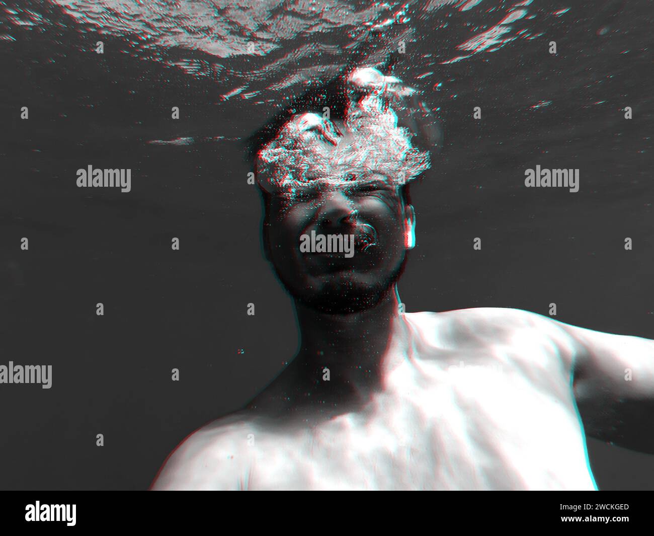 man is drowning in a deep blue sea under the water with an expression ...