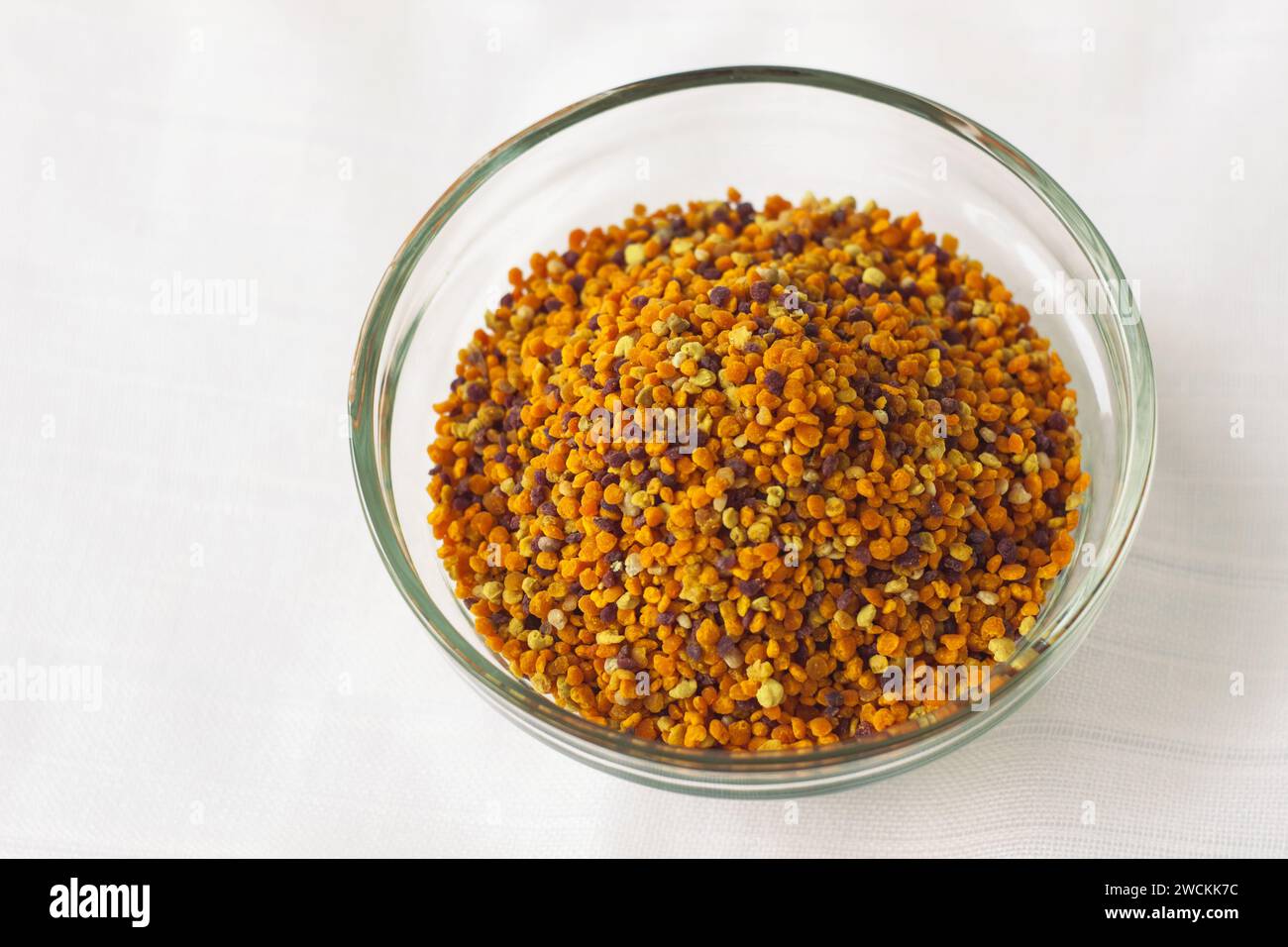 Bee pollen granules in a glass bowl on white background.Superfood ...