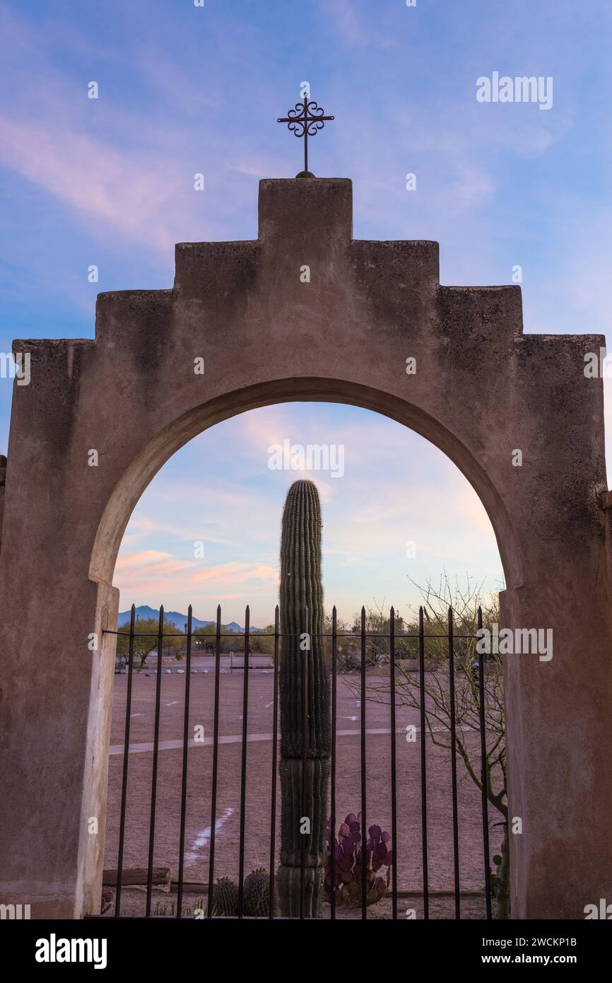 A saguaro cactus in front of the arched entry gate at the Mission San ...
