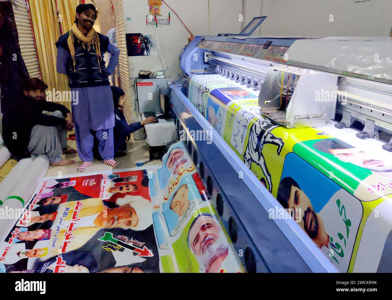 Laborers are working at a printing press busy in printing posters for ...