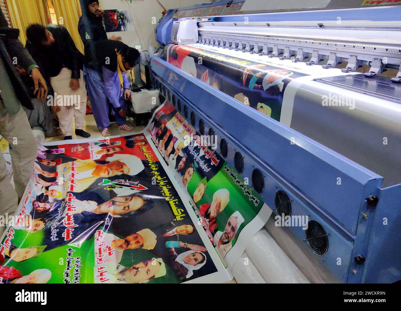Laborers are working at a printing press busy in printing posters for ...
