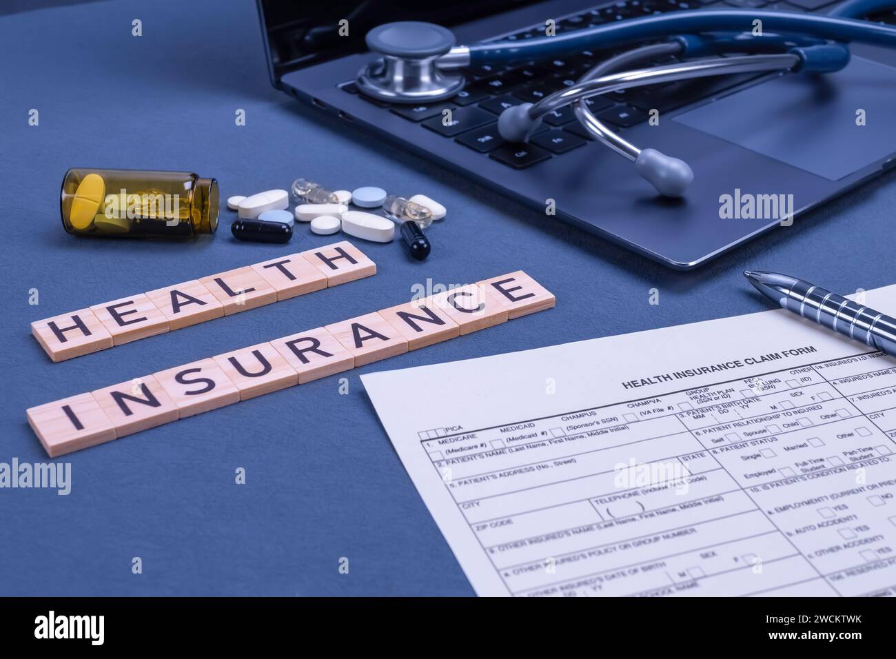 Health insurance form claim with laptop, stethoscope and pills on table ...