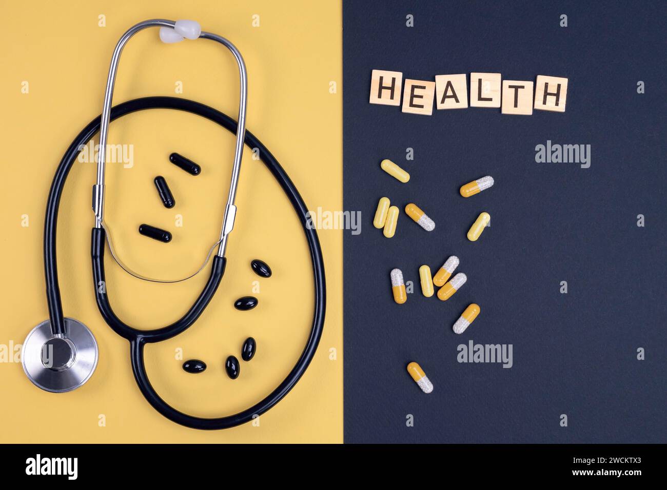 Stethoscope and capsules on yellow and black background. Healthcare ...