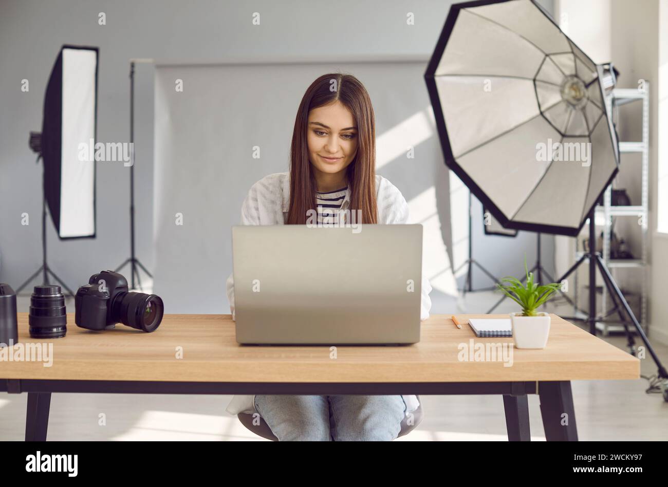 Beautiful woman photographer editing photos on laptop computer in ...