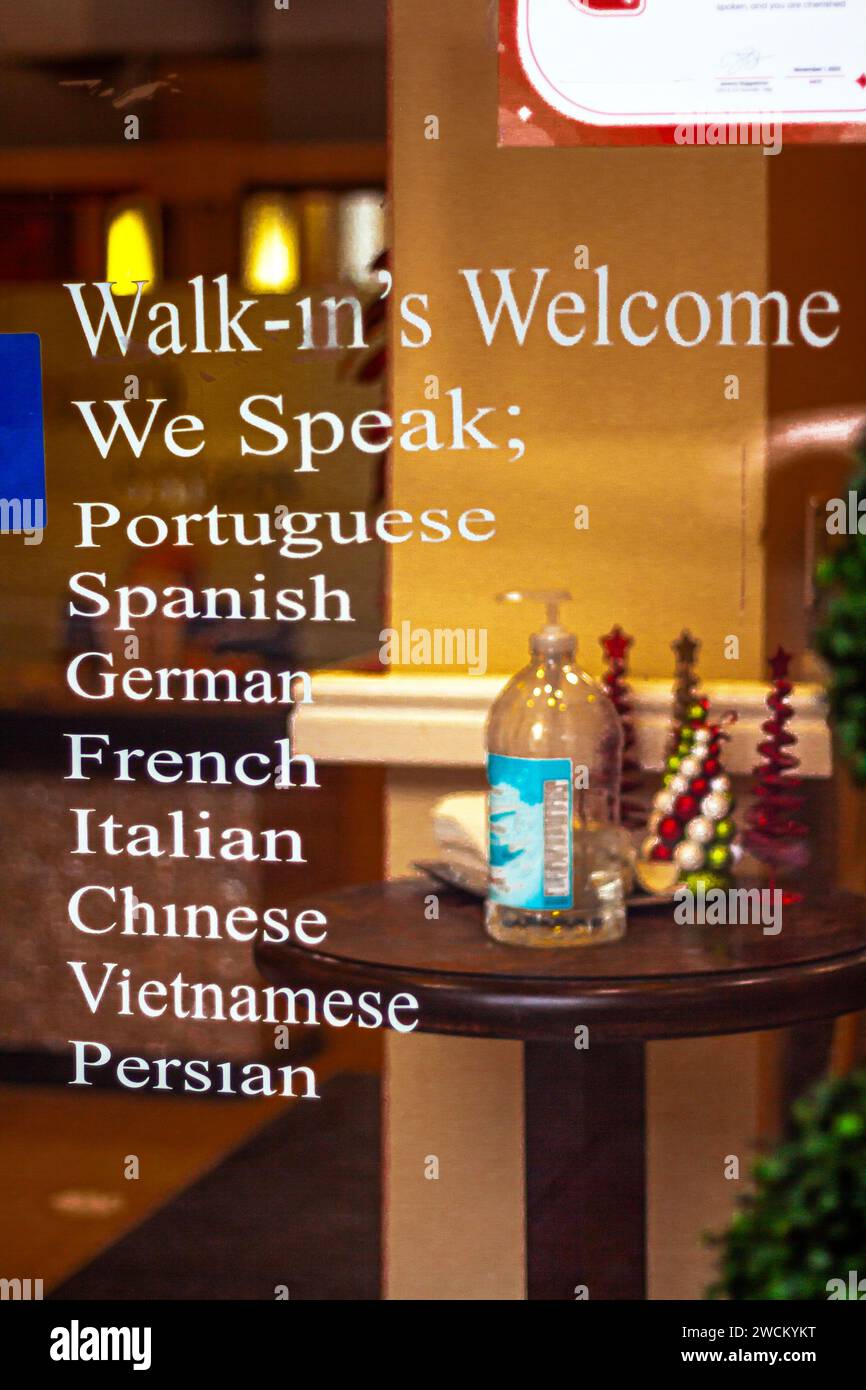Sign advertising multiple languages spoken at the business Stock Photo ...