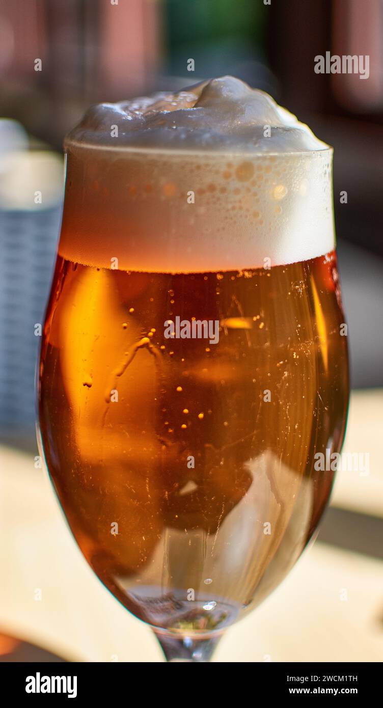 A good pint of German beer with its bright dark yellow color and white ...