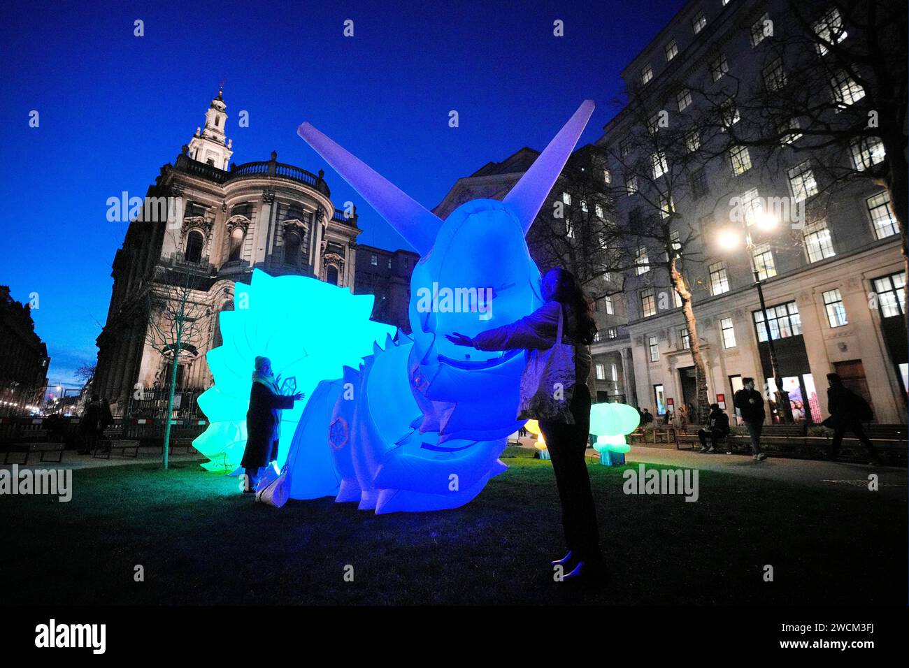 People interact with a giant inflatable robot as they are unveiled ...