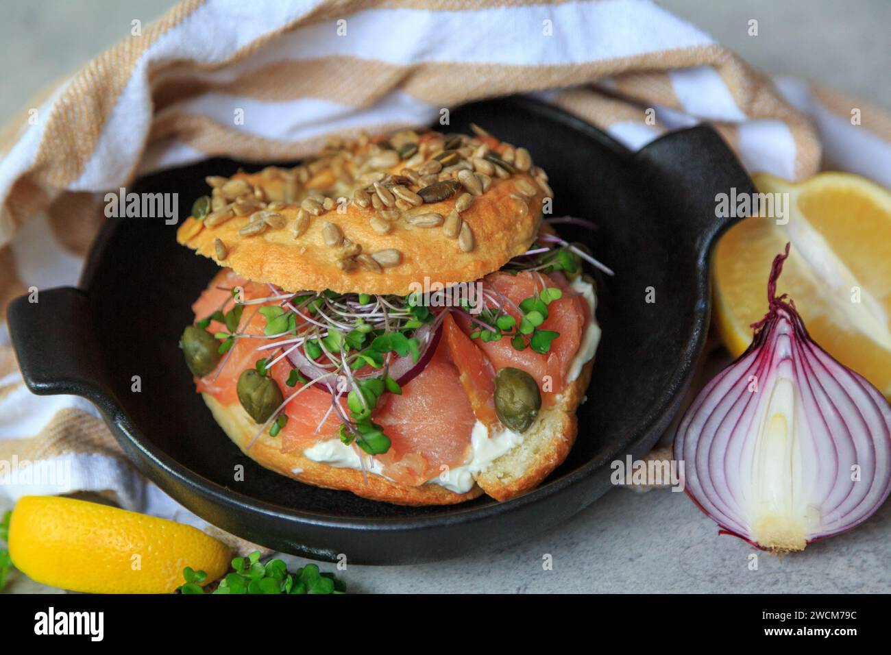 A delectable smoked salmon bagel adorned with vibrant microgreens, red ...