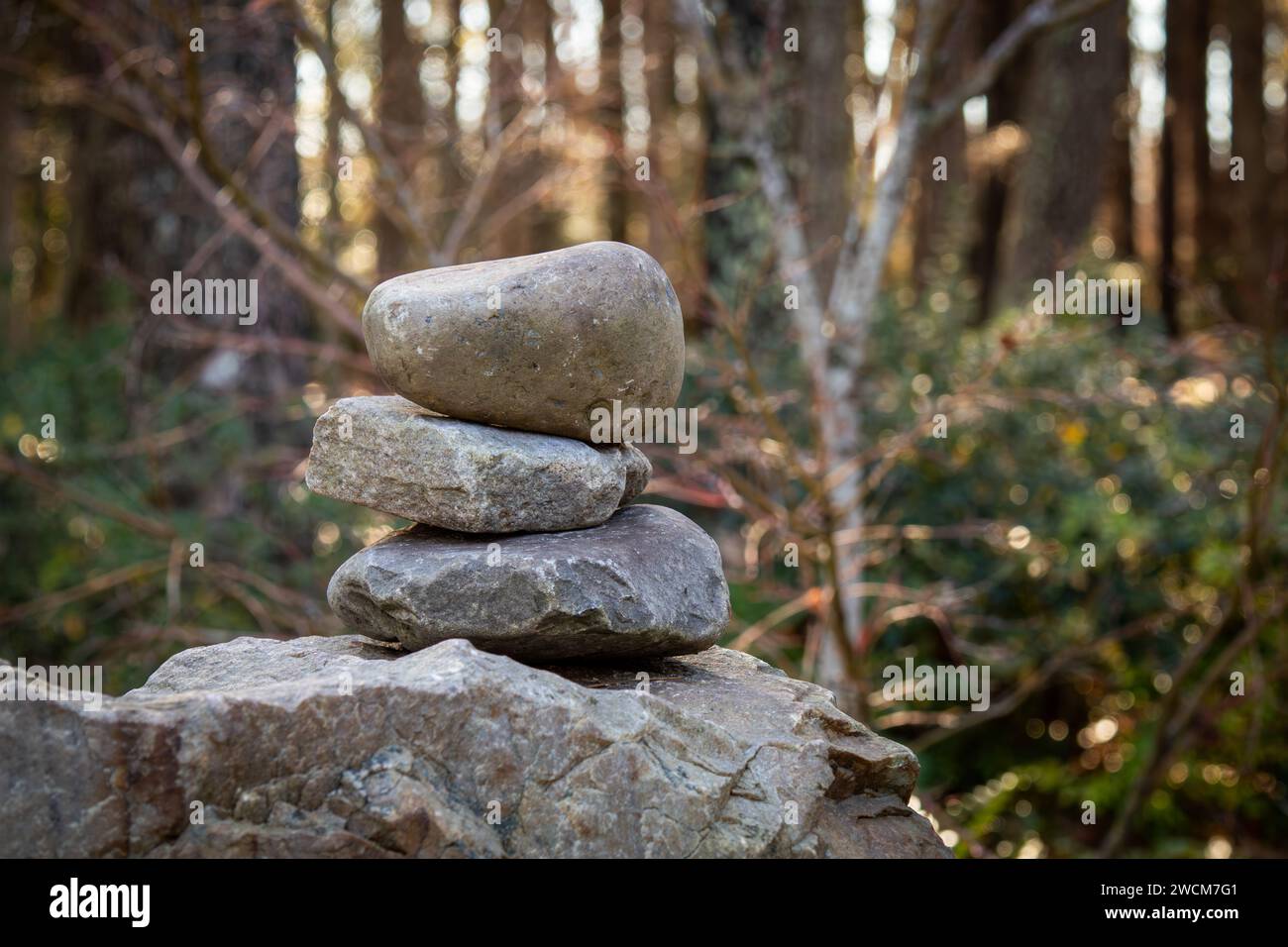Three Small Stacked Stones Balancing on Large Stone in Sunlit Garden ...
