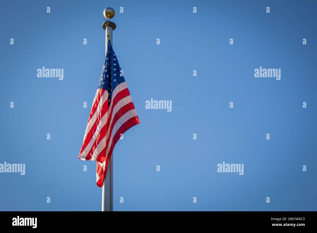 Majestic American Flag with Clear Blue Sky Stock Photo - Alamy