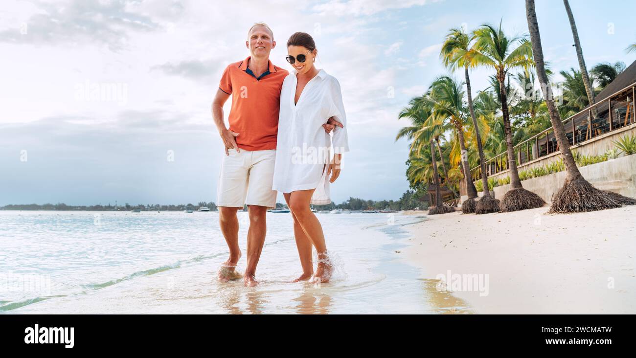 Couple in love hugging while walking on a sandy exotic beach. They have ...