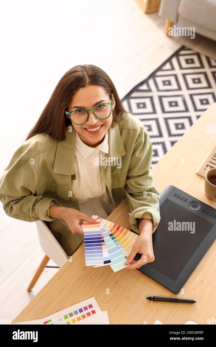 Female interior designer working with color palettes at table in office ...