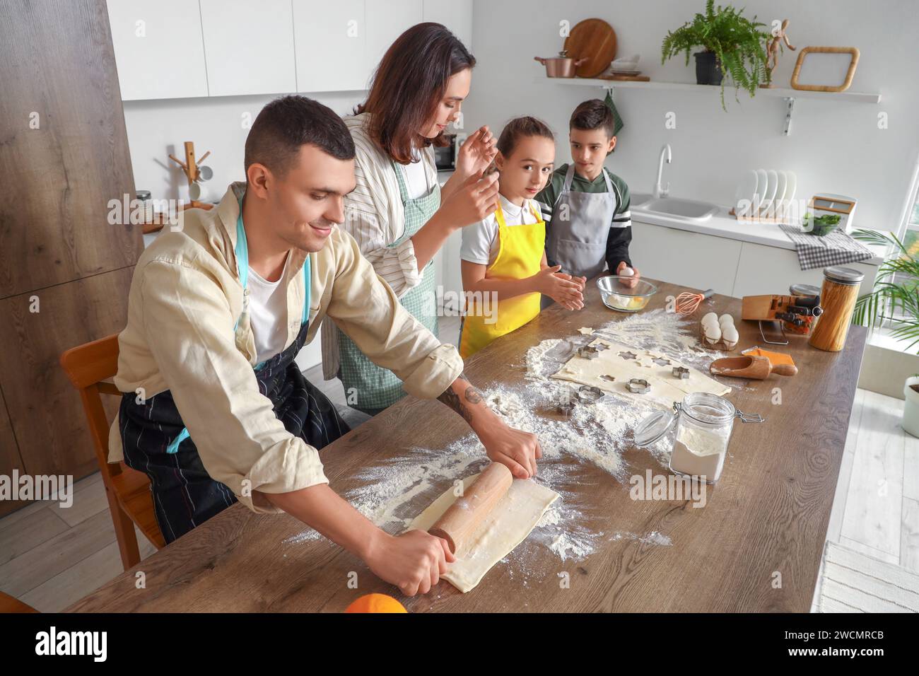 Happy family making cookies in kitchen Stock Photo - Alamy