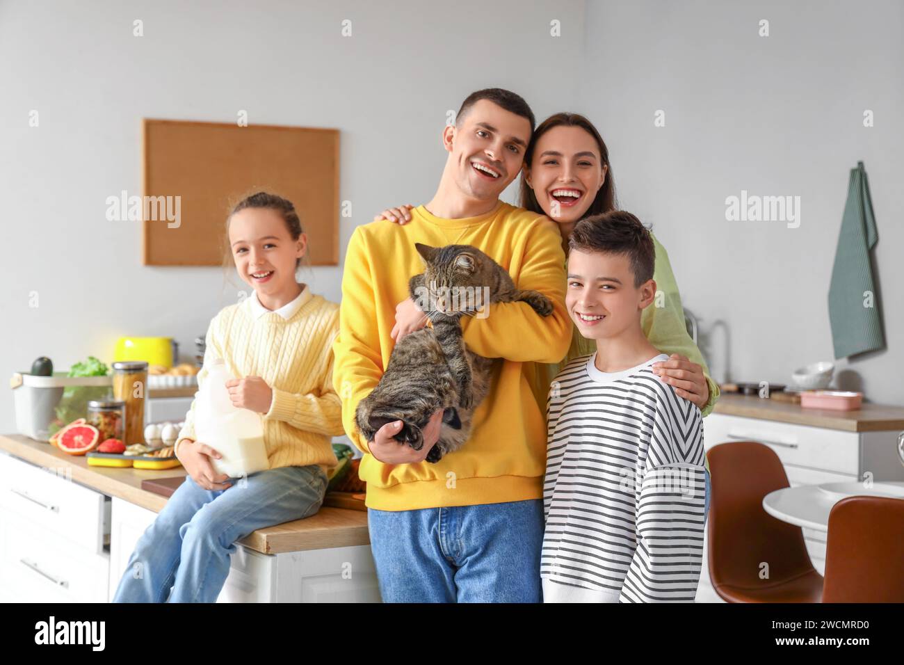 Happy family with cat in kitchen Stock Photo - Alamy