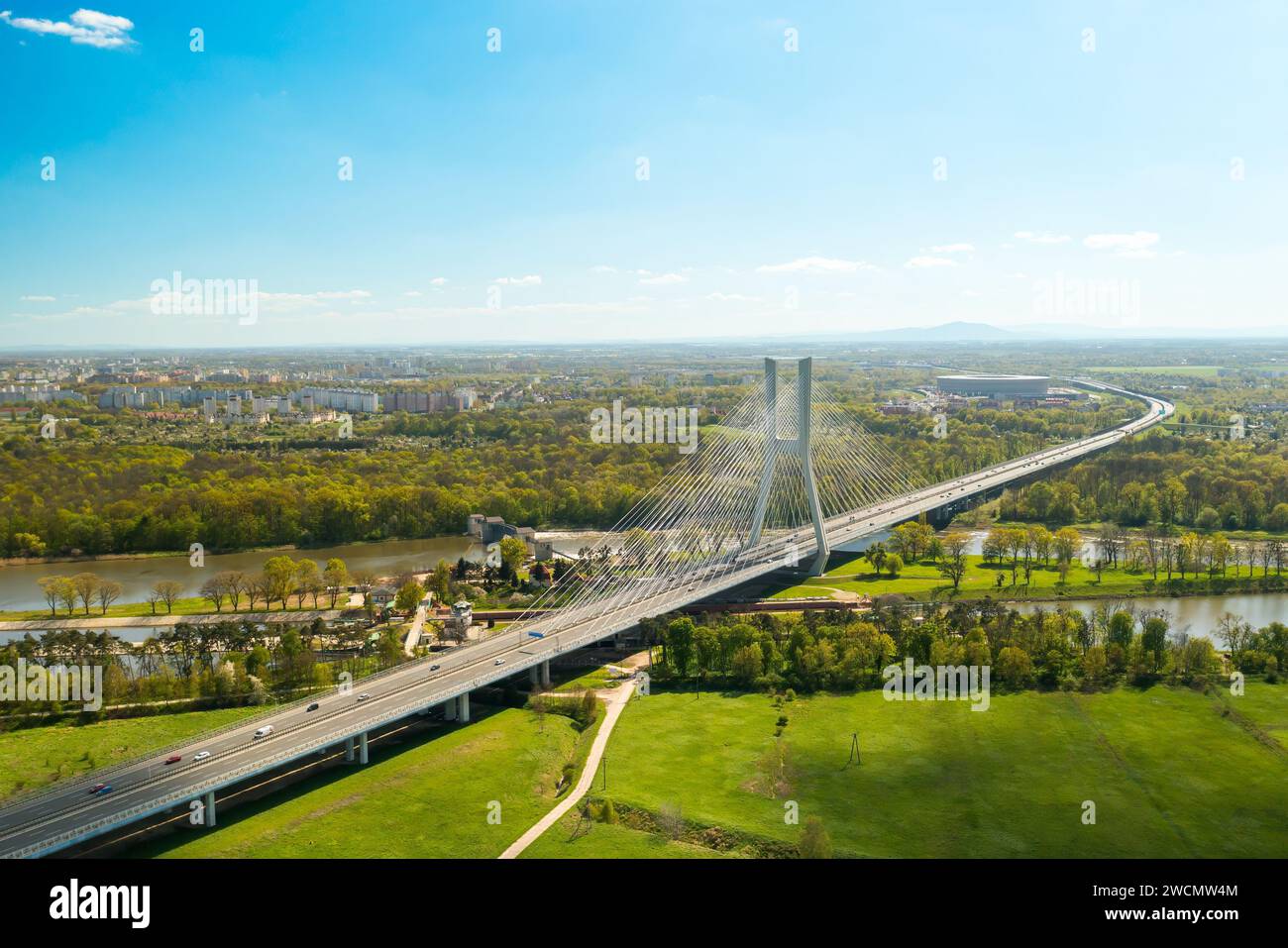 Cars drive on cable-stayed bridge under clear blue sky. Massive ...