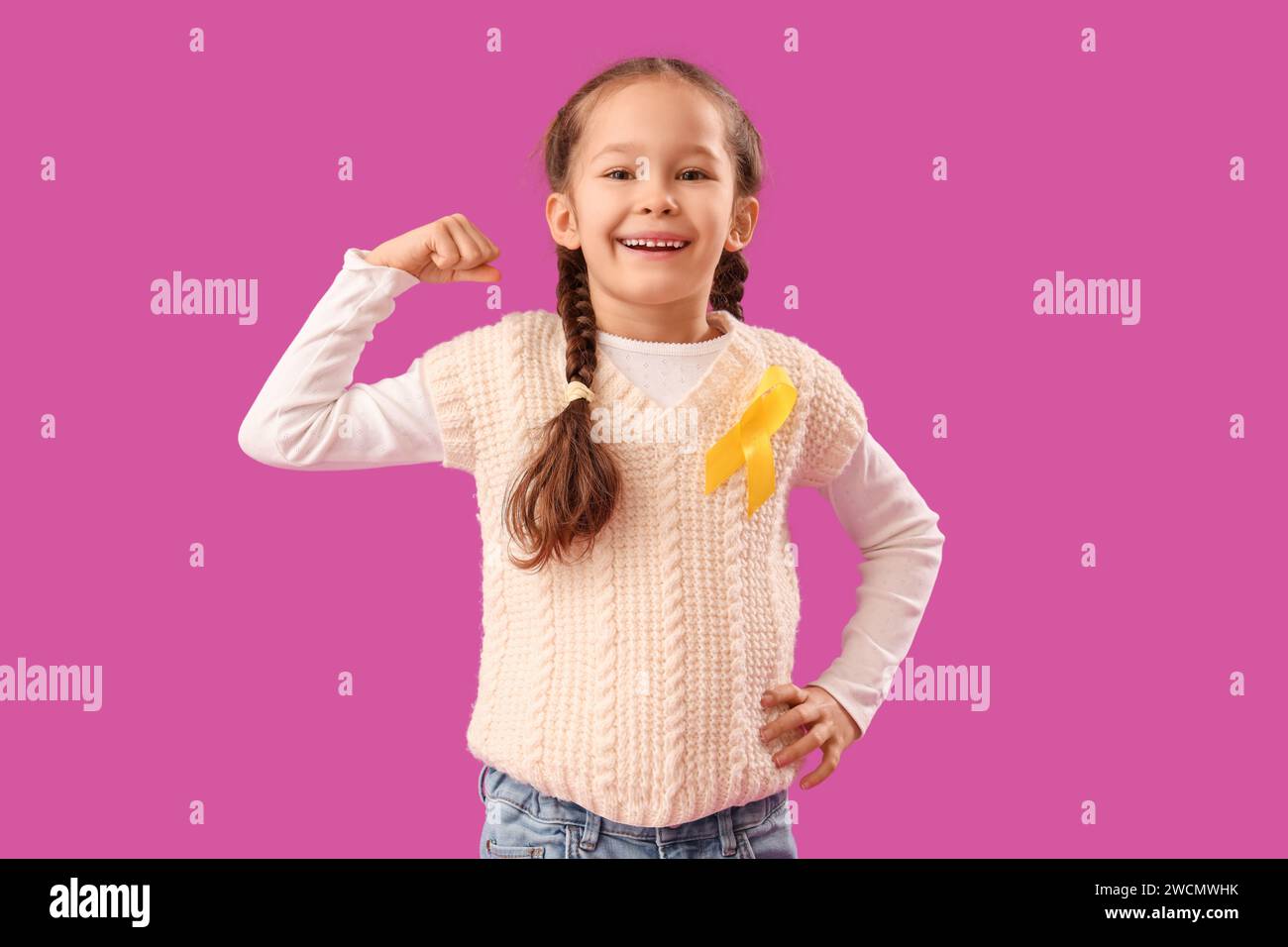 Cute little girl with yellow ribbon showing muscles on purple ...