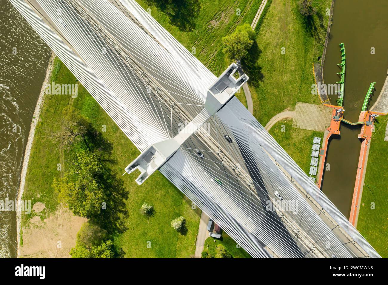 Top view of cable-stayed pylon bridge above urban parks with green ...