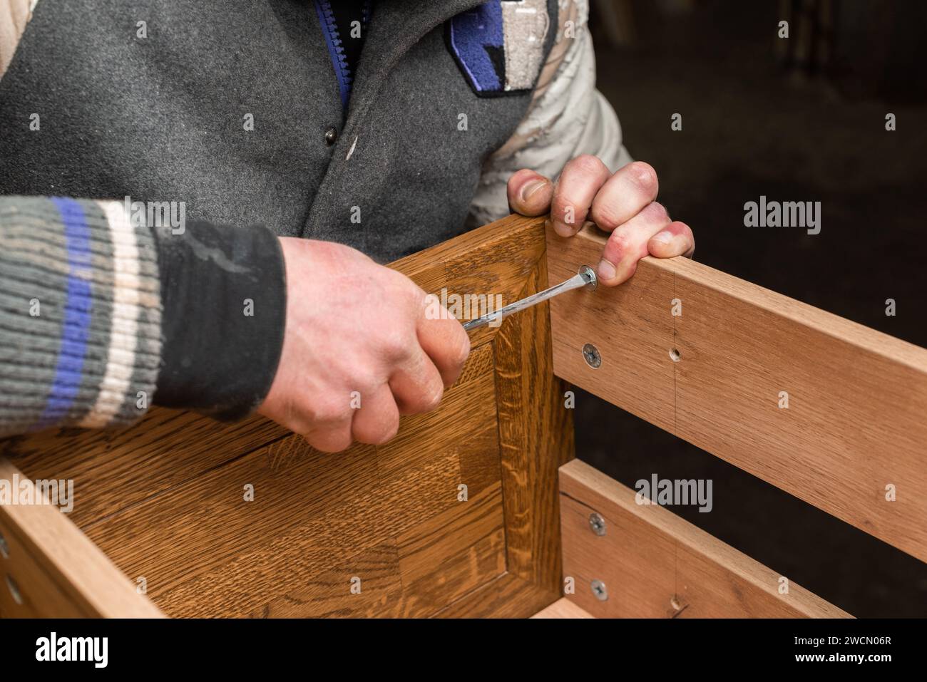 The joiner connects the panels with a screwdriver closeup Stock Photo ...