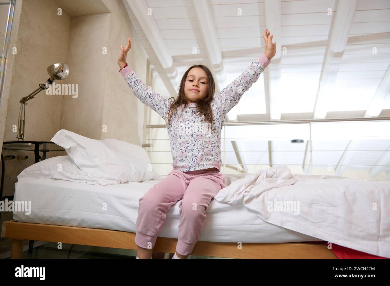 Caucasian beautiful little girl waking up in the morning, stretching ...