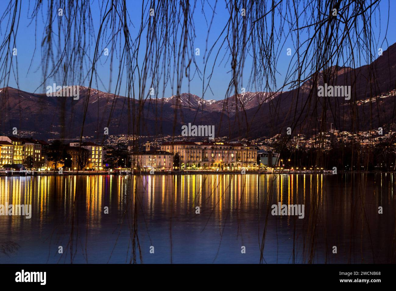 Lake Lugano at blue hour time with city light reflection on water ...