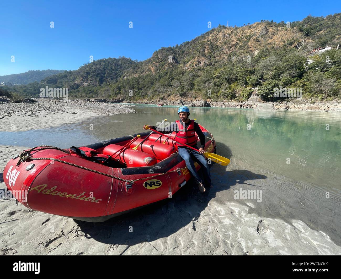 Two men in a red inflatable raft on a riverbank Stock Photo - Alamy