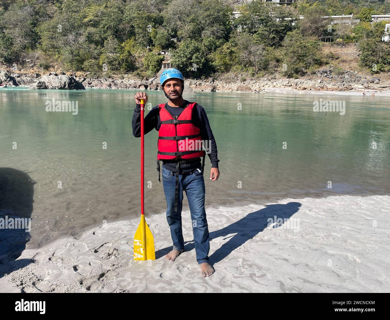 Man holding raft and paddle by water Stock Photo - Alamy