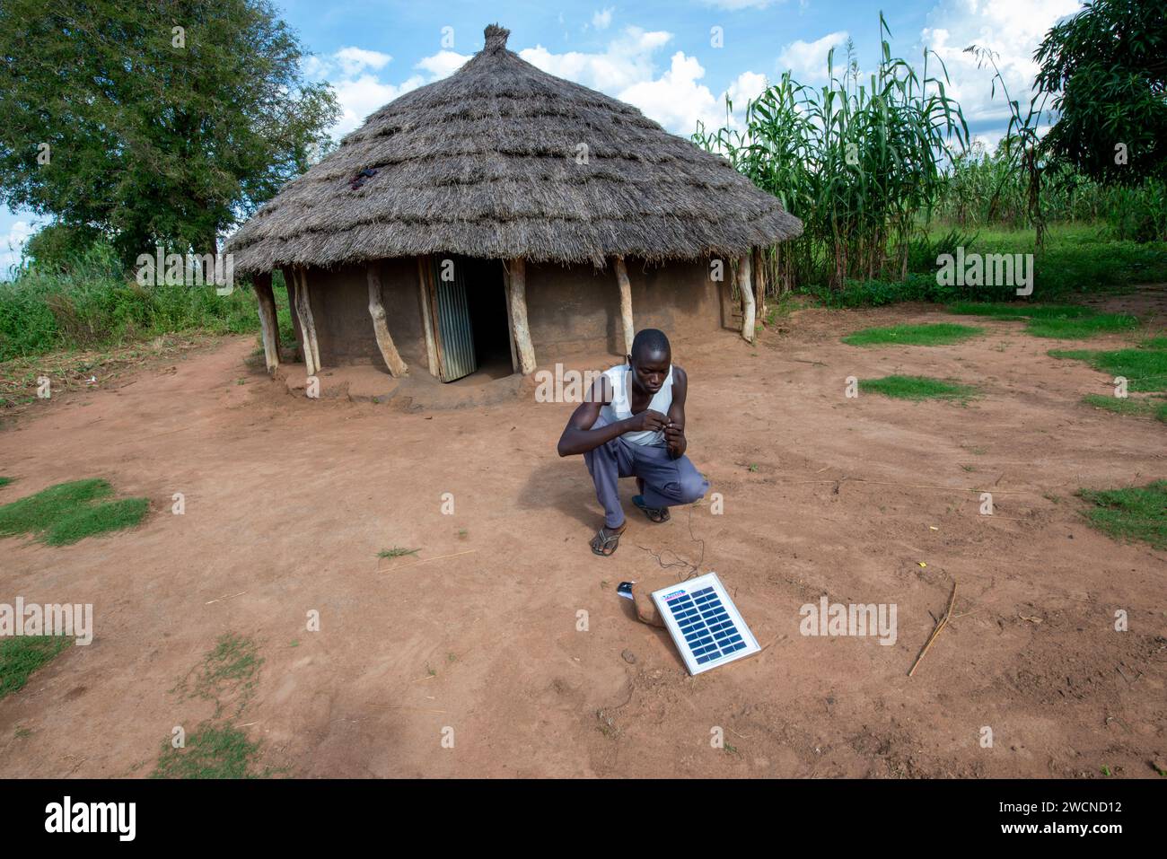 Uganda, Kitgum District. Young man generating light for his home with a solar panels. Editorial ...