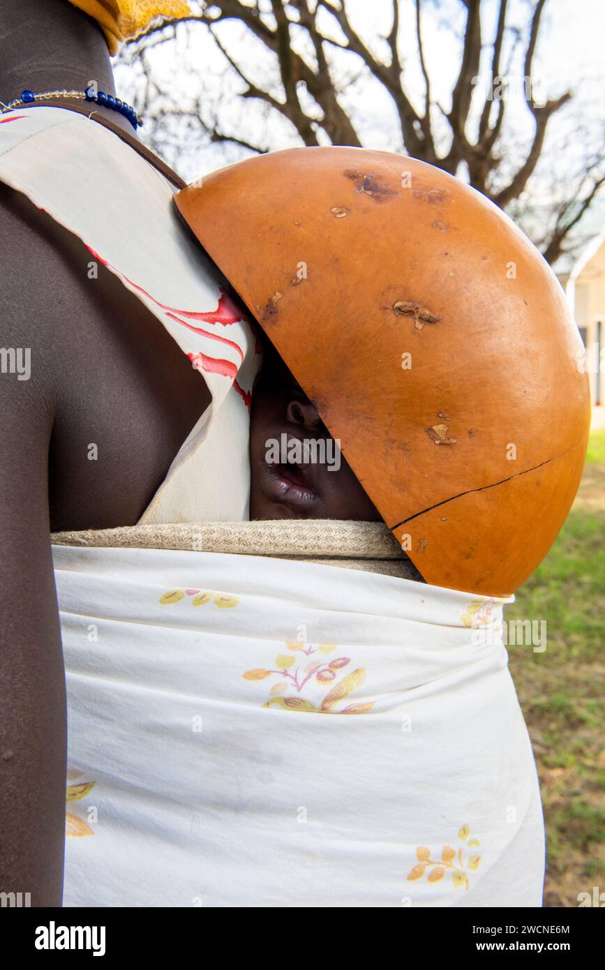 N. Uganda, Kitgum District. A mother keeps her baby's head protected ...