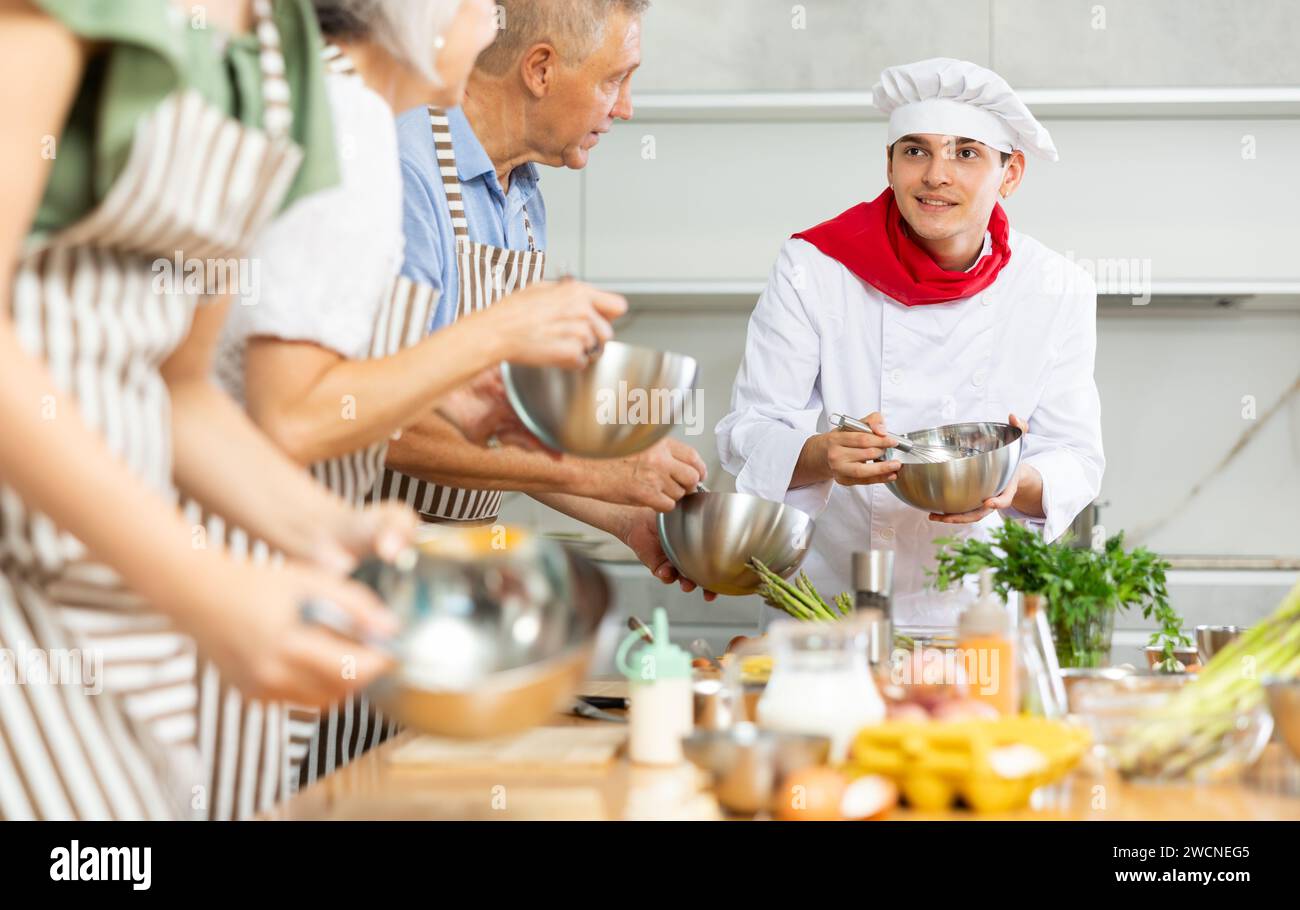 Young guy cook teaches to cook group of people Stock Photo - Alamy