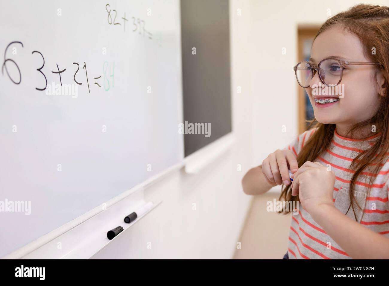 Little girl counting math equation on whiteboard in school Stock Photo ...