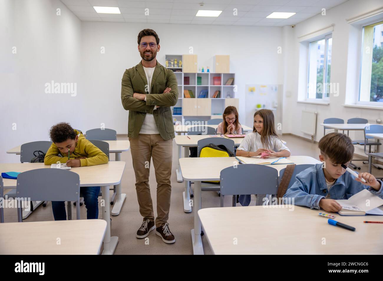 Man teacher in classroom with little students Stock Photo - Alamy