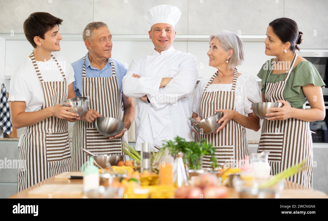 Successful male chef posing with group at cooking course Stock Photo ...