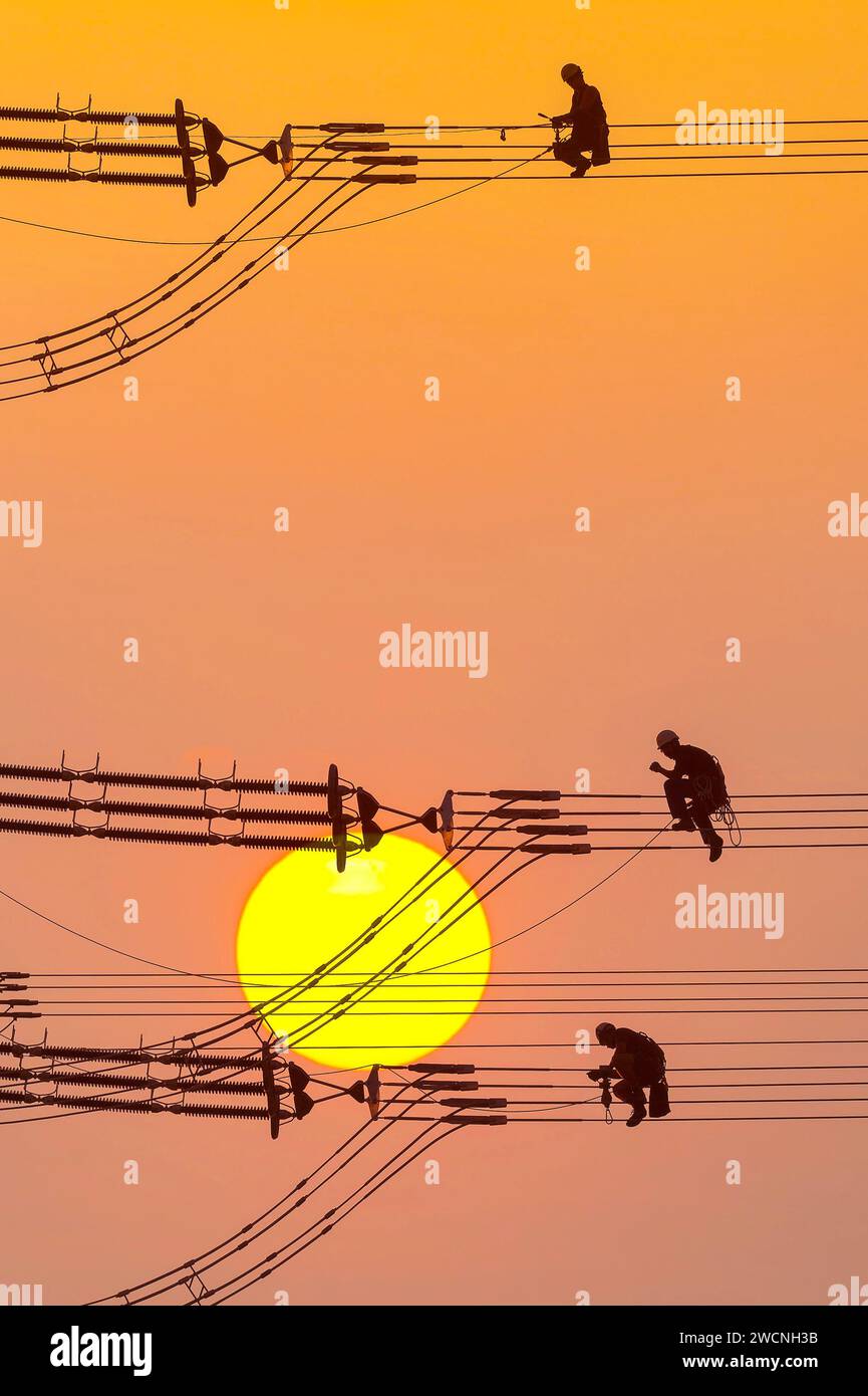 Photomontage, overhead line fitters working on a high-voltage pylon ...