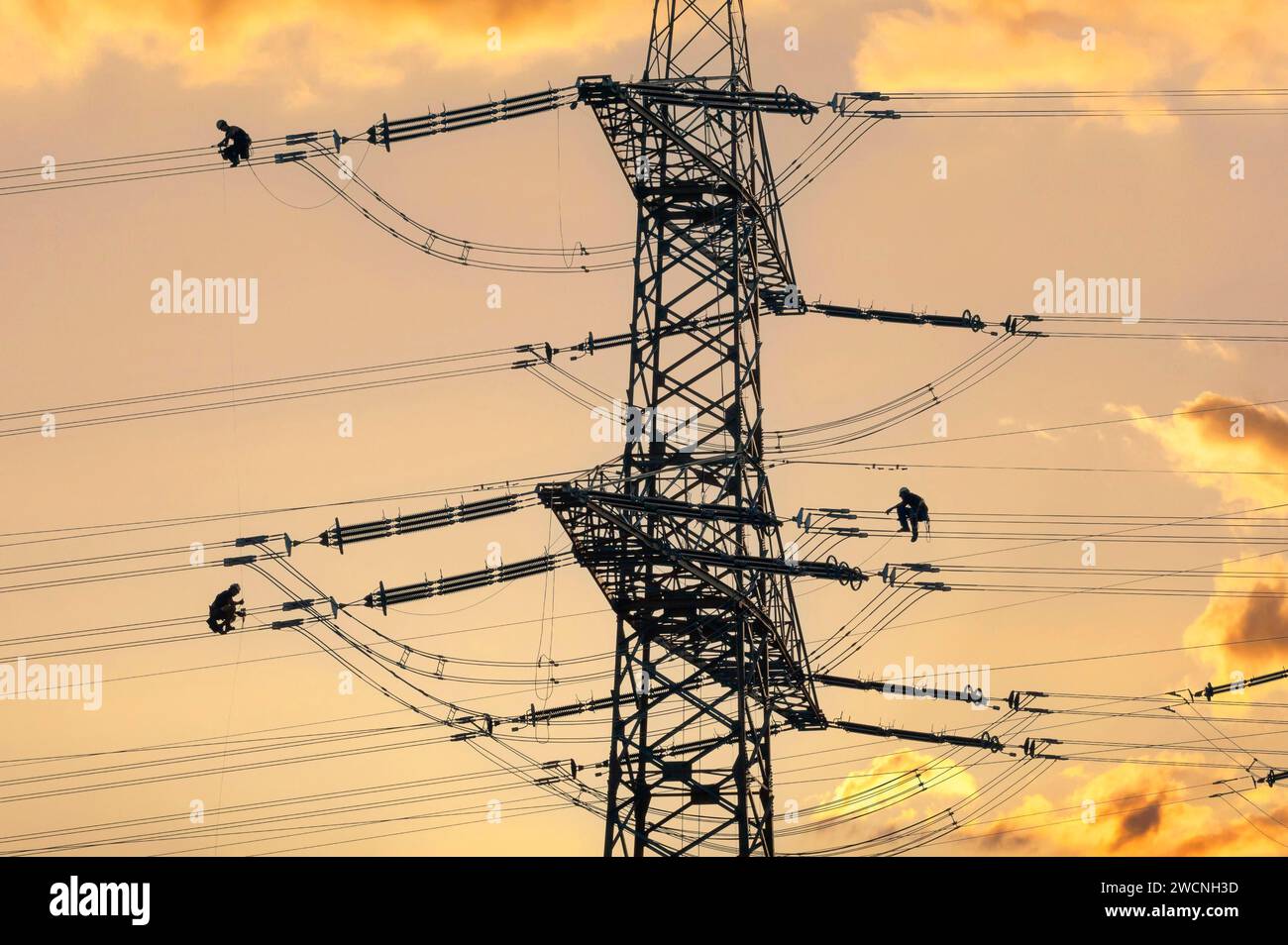 Overhead line fitters working on a high-voltage pylon, overhead lines ...
