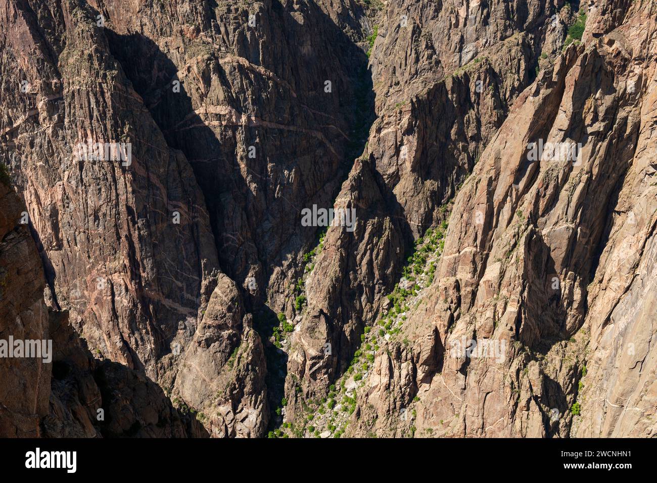 Massive rocks in shadows and light in the depths of the Black Canyon of ...