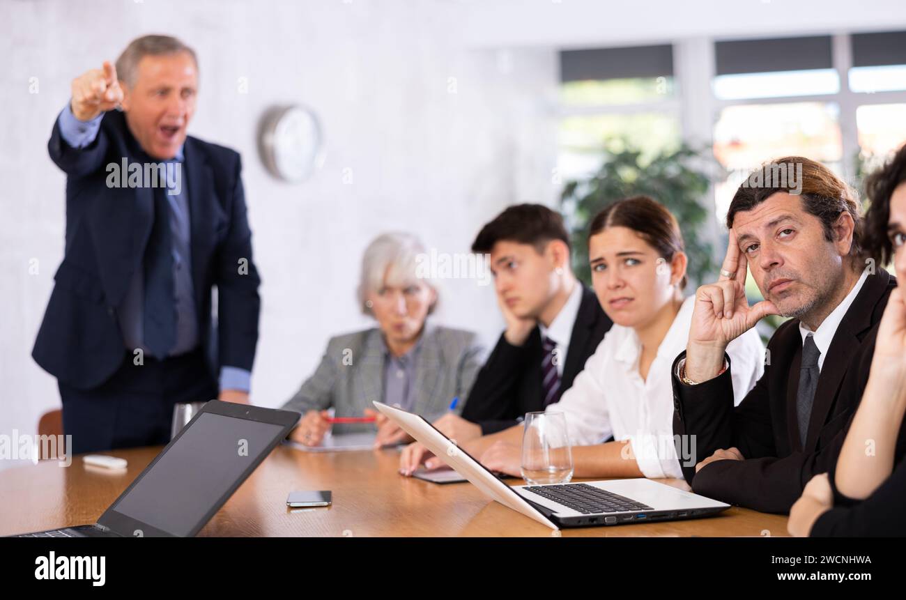 Outraged old manager getting mad at young adult mature office workers ...