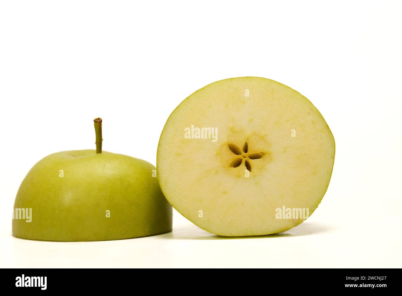 Close-up of a fresh green apple cut in half isolated on white ...