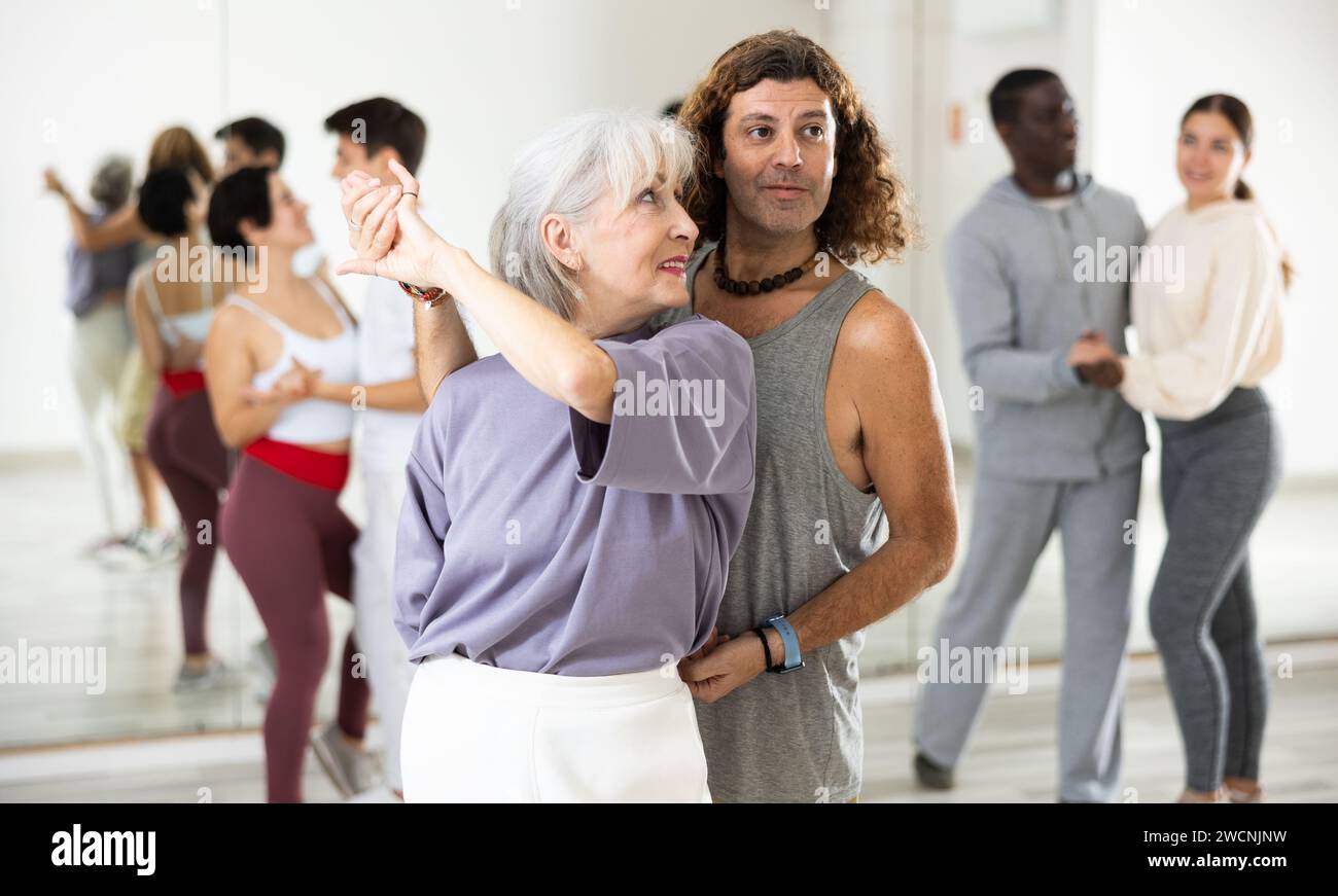 Dancing positive couples learning salsa Stock Photo - Alamy