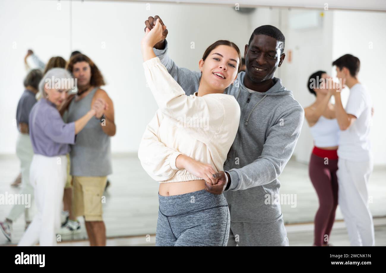 Dancing positive couples learning salsa Stock Photo - Alamy