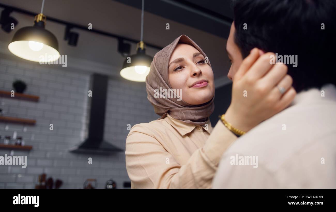 Romantic married young couple standing at home, the woman caresses her ...