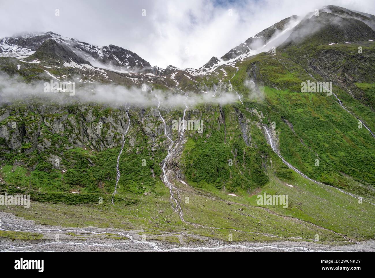 Mountain streams flow over steep mountain slopes into the tagl of the ...