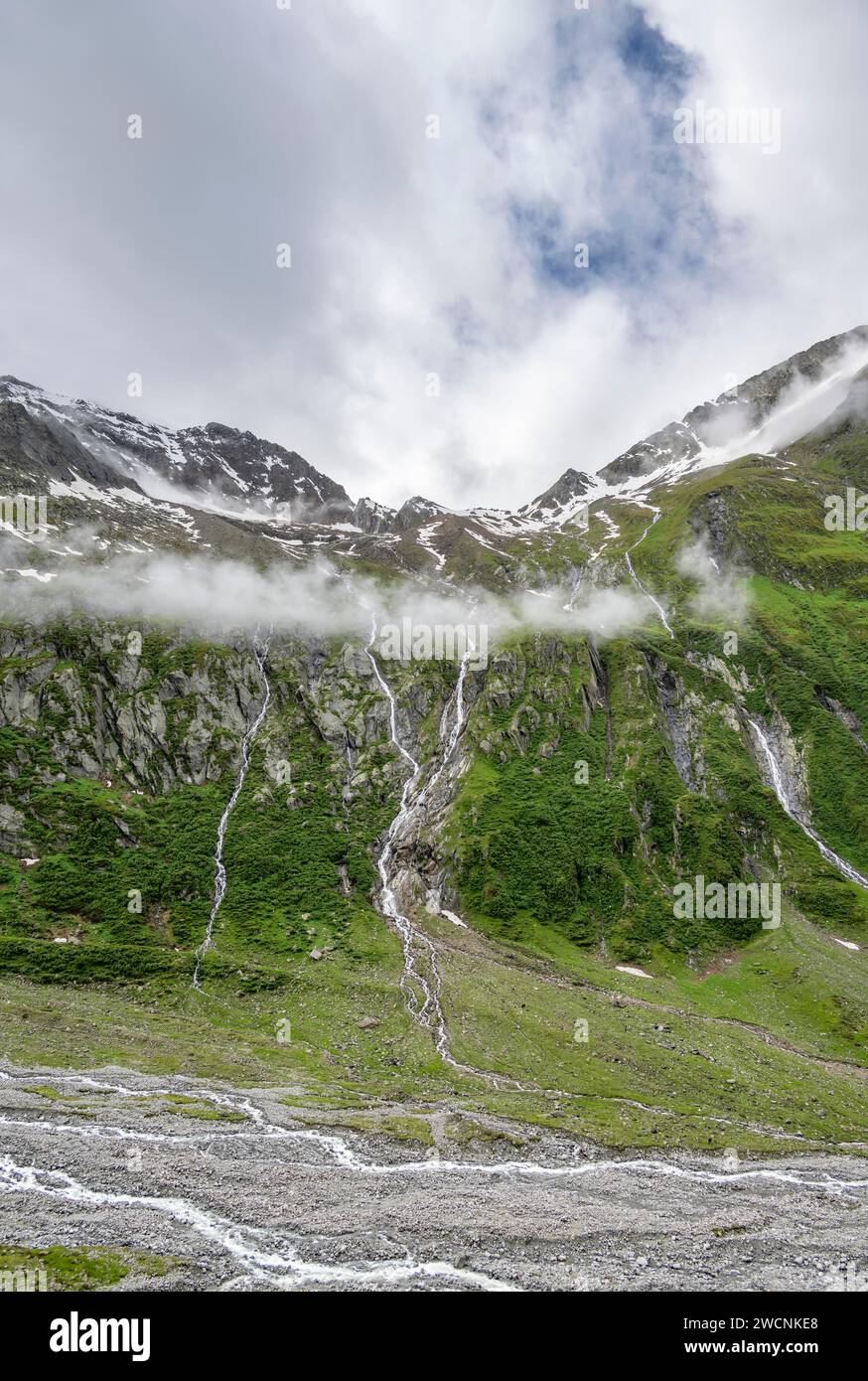 Mountain streams flow over steep mountain slopes into the ...
