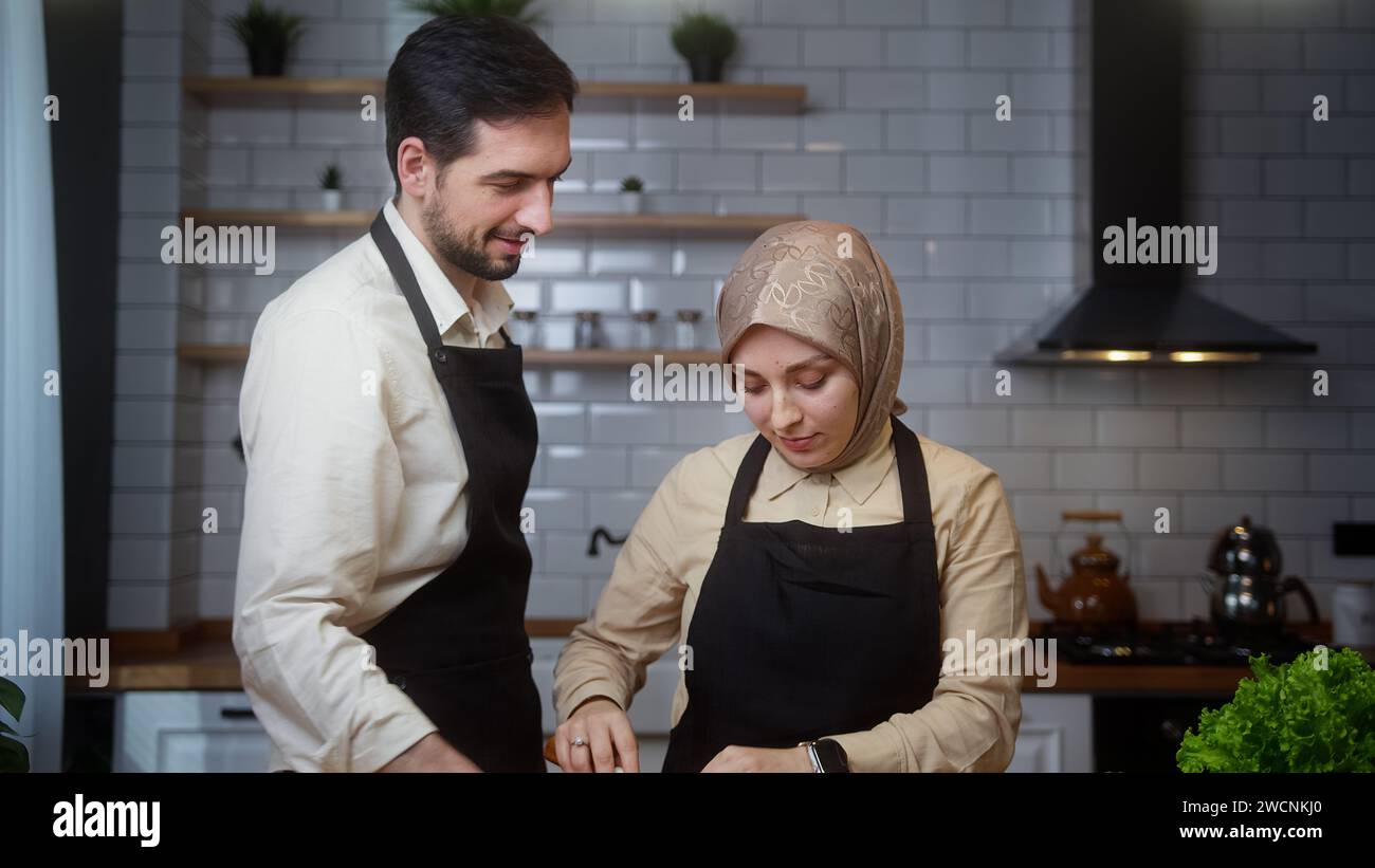 A married couple enjoy conversation in the modern kitchen and prepare ...
